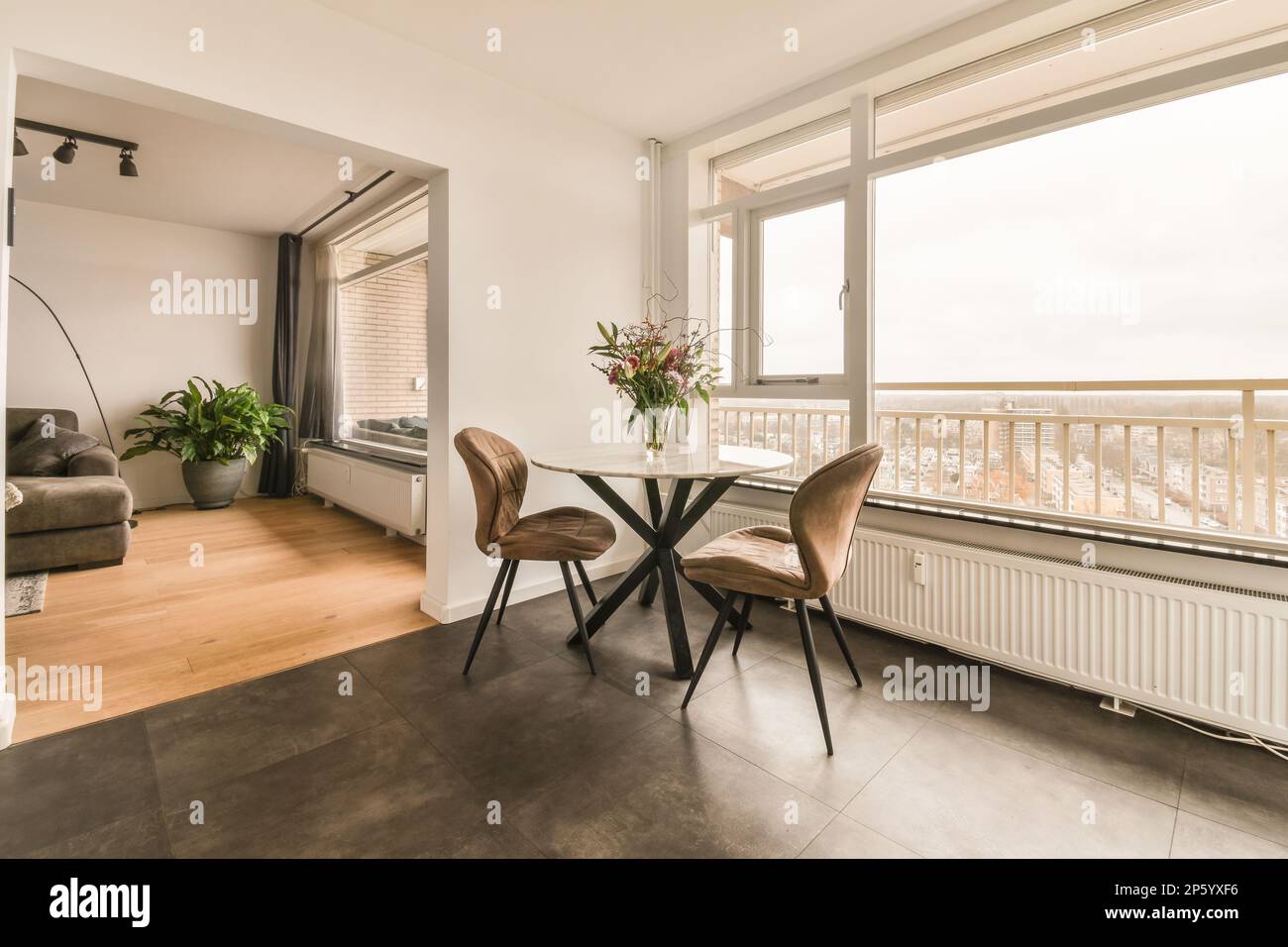 a living room with two chairs and a table in front of a large window ...
