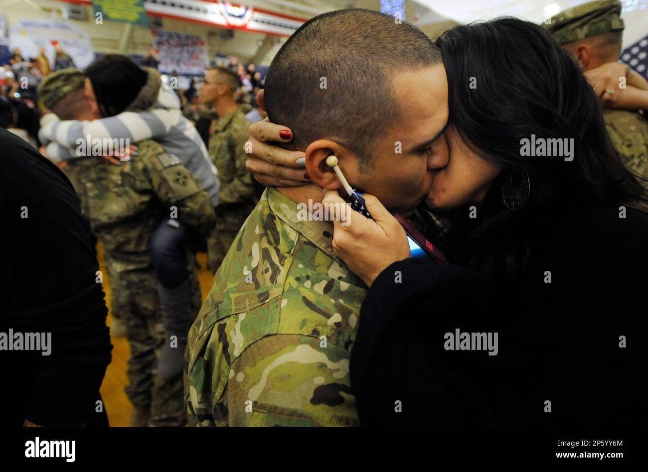 Cassandra Castro, right, gives a welcome-home kiss to her husband, Spc ...