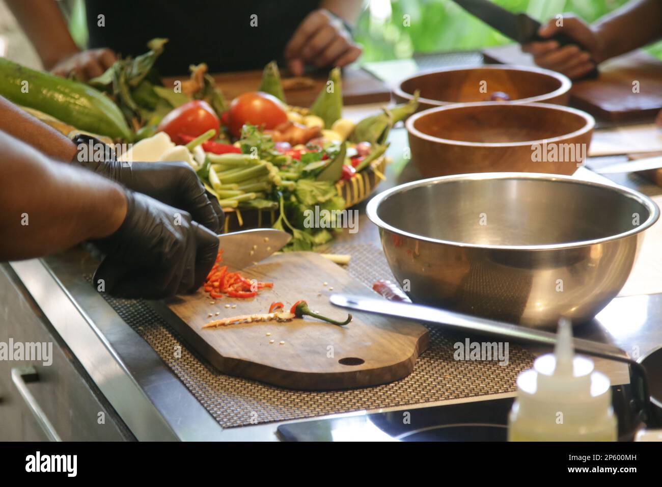 Adult students learning recipe and preparing meal in cooking class ...