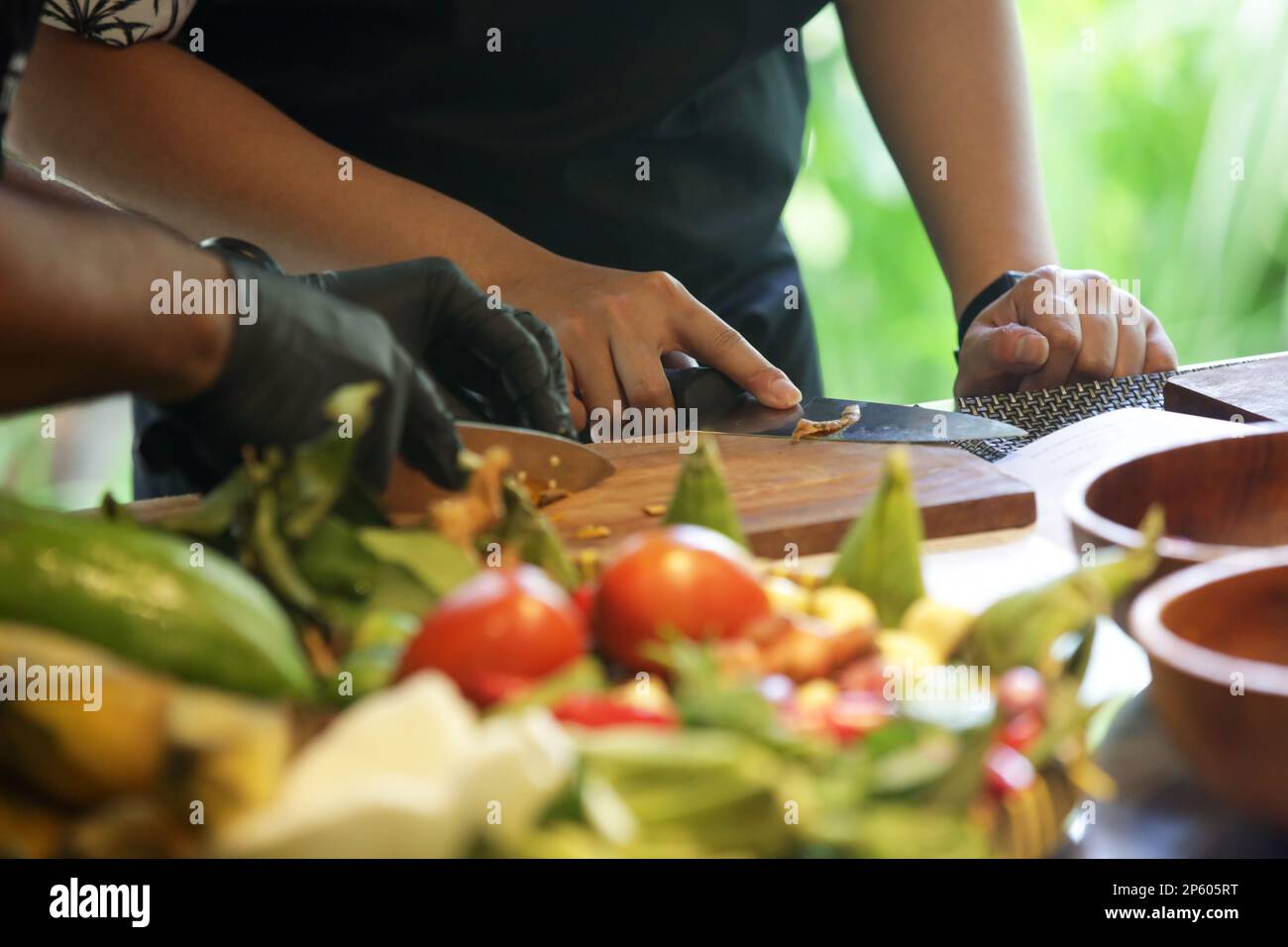 Adult students learning recipe and preparing meal in cooking class ...