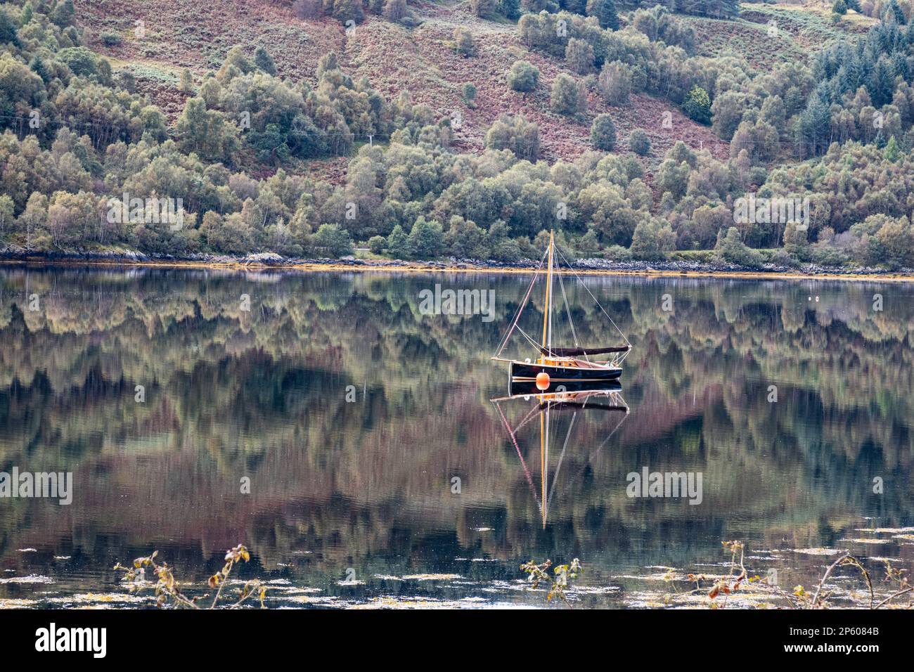 Sailing boat with reflection at anchor at Strontian, in Loch Sunart ...