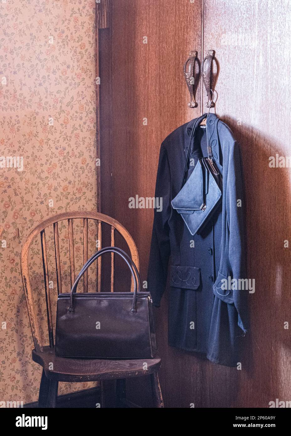 Old fashioned vintage 1950s clothes hung up on a wardrobe in a bedroom ...