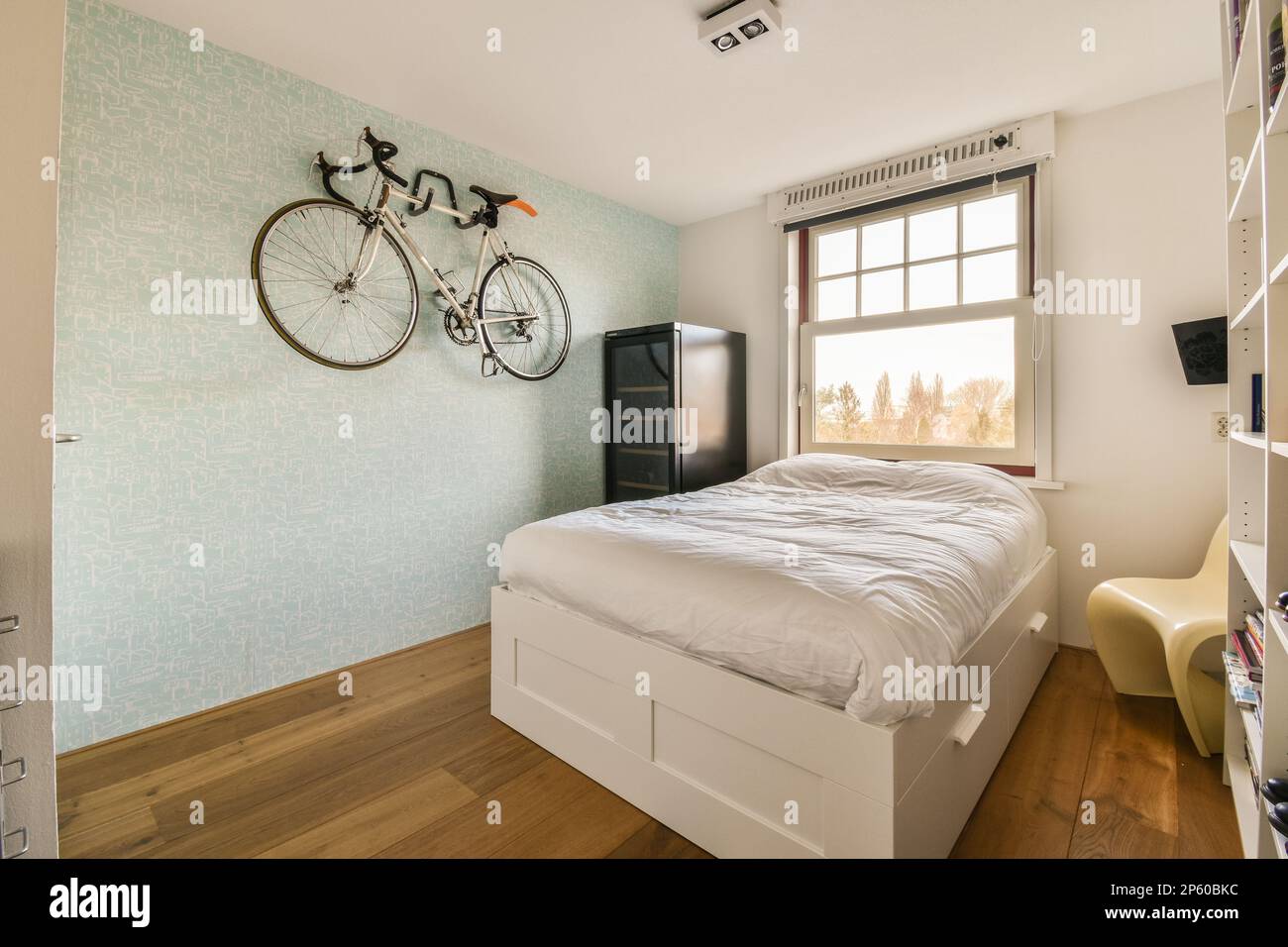 a bedroom with a bike mounted on the wall above it and a bed that has ...