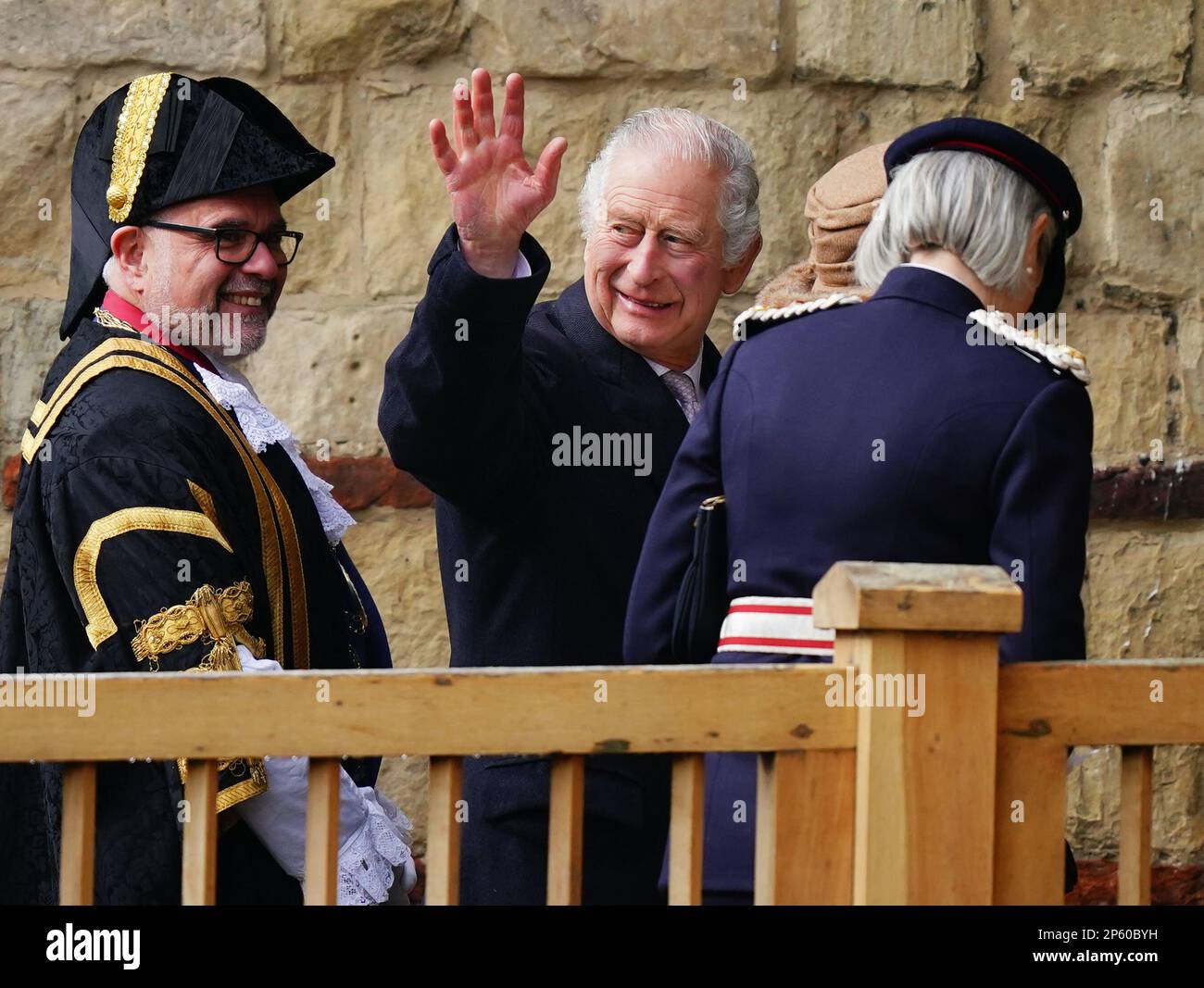 King Charles III waves to the gathered crowd as he arrives for a visit ...