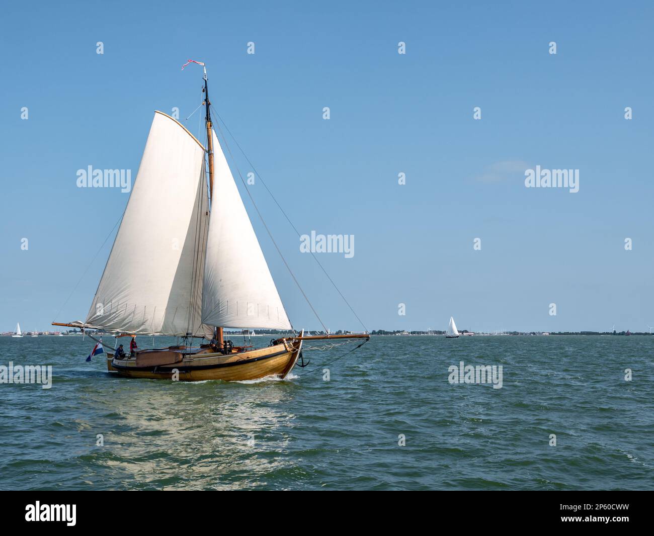 Small traditional classic sailboat sailing under full sails on ...