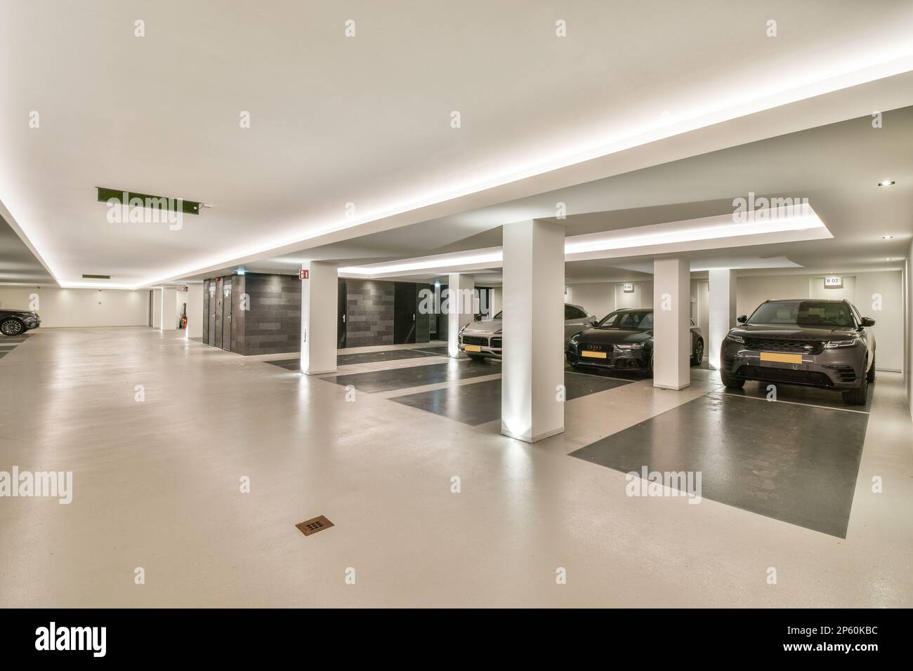 the inside of a car showroom with two cars parked in the garage and an ...