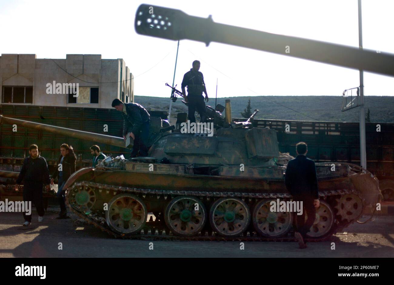 Syrian fighters check a tank they took after storming a military base ...