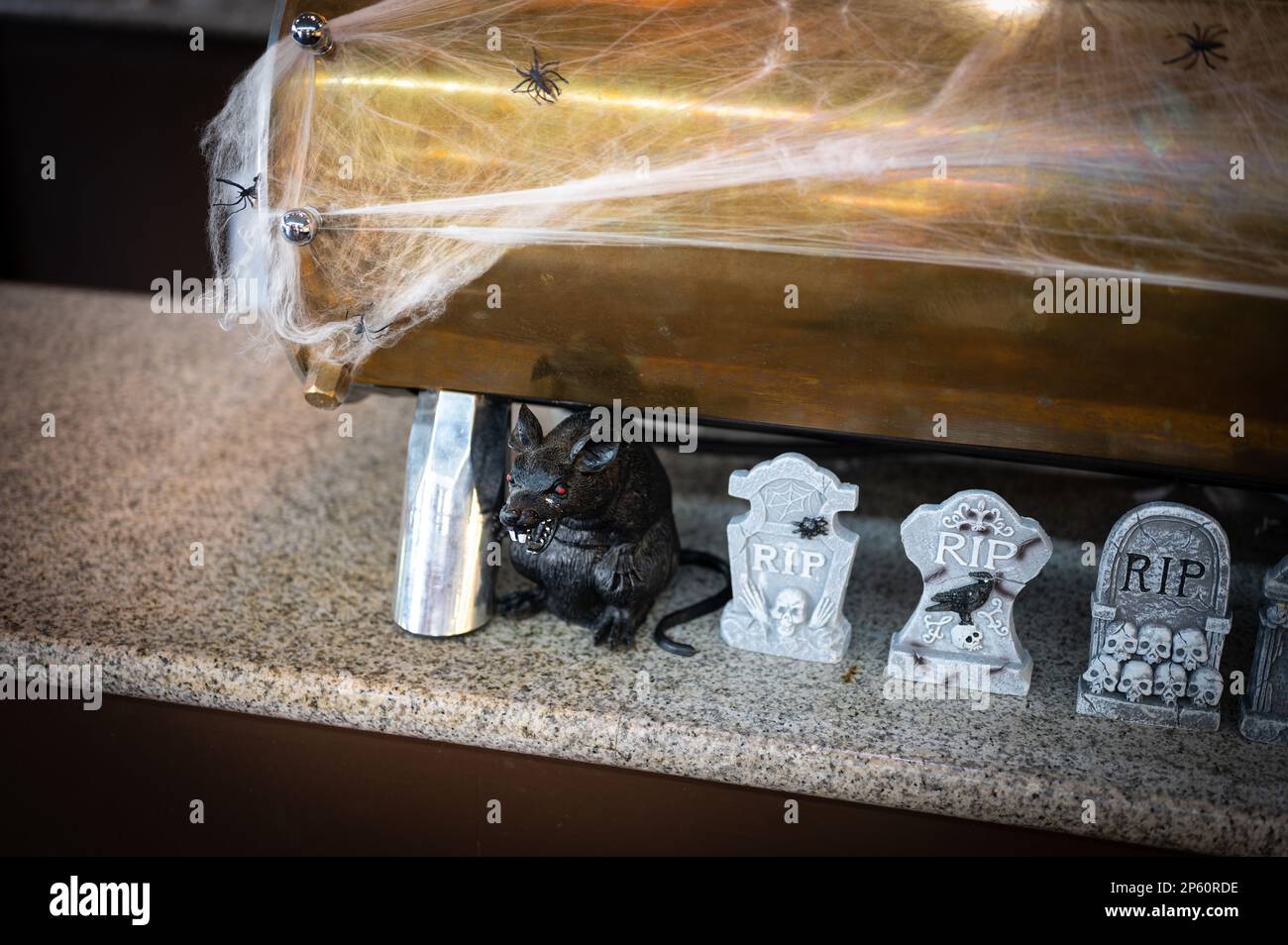 Halloween decoration, a rat peeks out from under the coffee pot of a ...