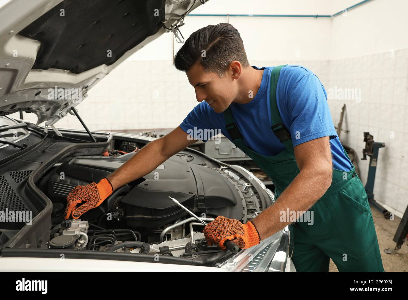 Professional mechanic fixing modern car at automobile repair shop Stock ...