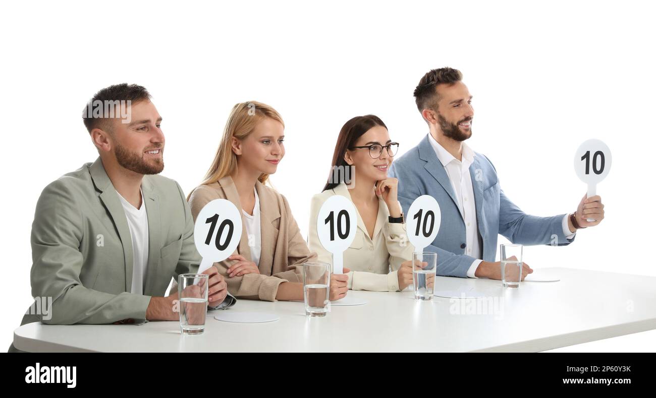 Panel of judges holding signs with highest score at table on white ...