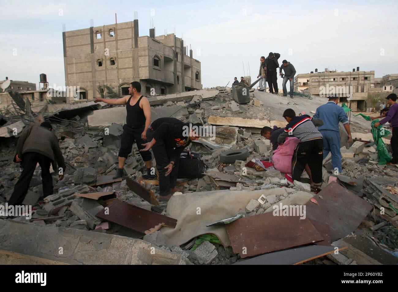 Palestinians inspect the rubble of the destroyed house of Hamas ...