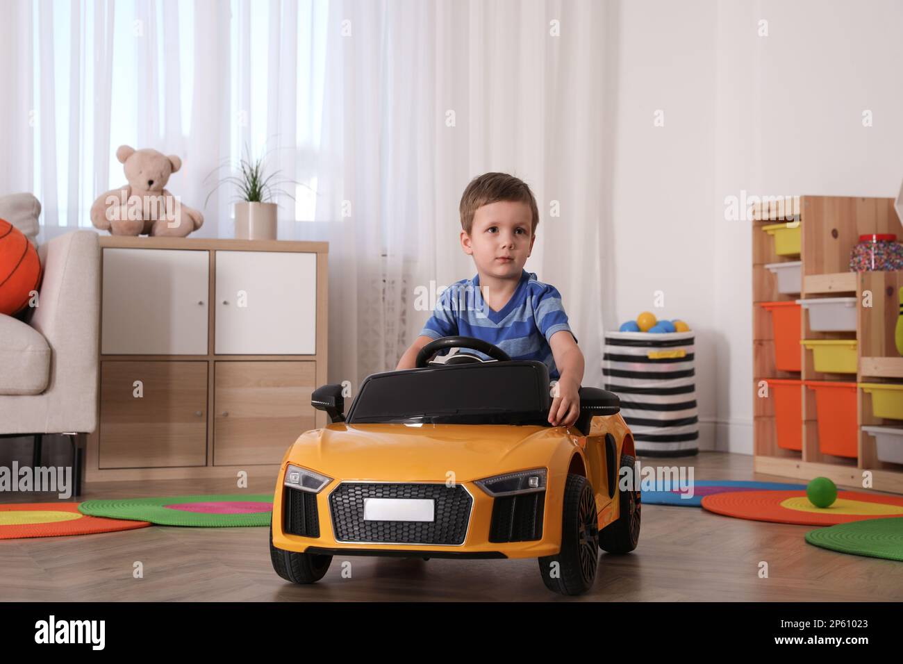 Little child playing with toy car in room Stock Photo - Alamy