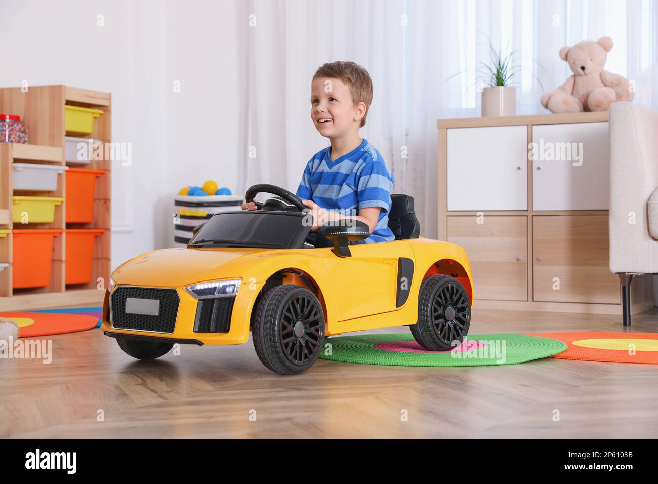Little child playing with toy car in room Stock Photo - Alamy