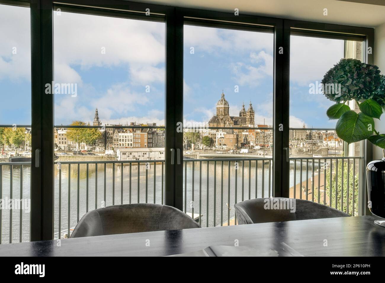 a city from inside a room with large windows looking out onto the river ...