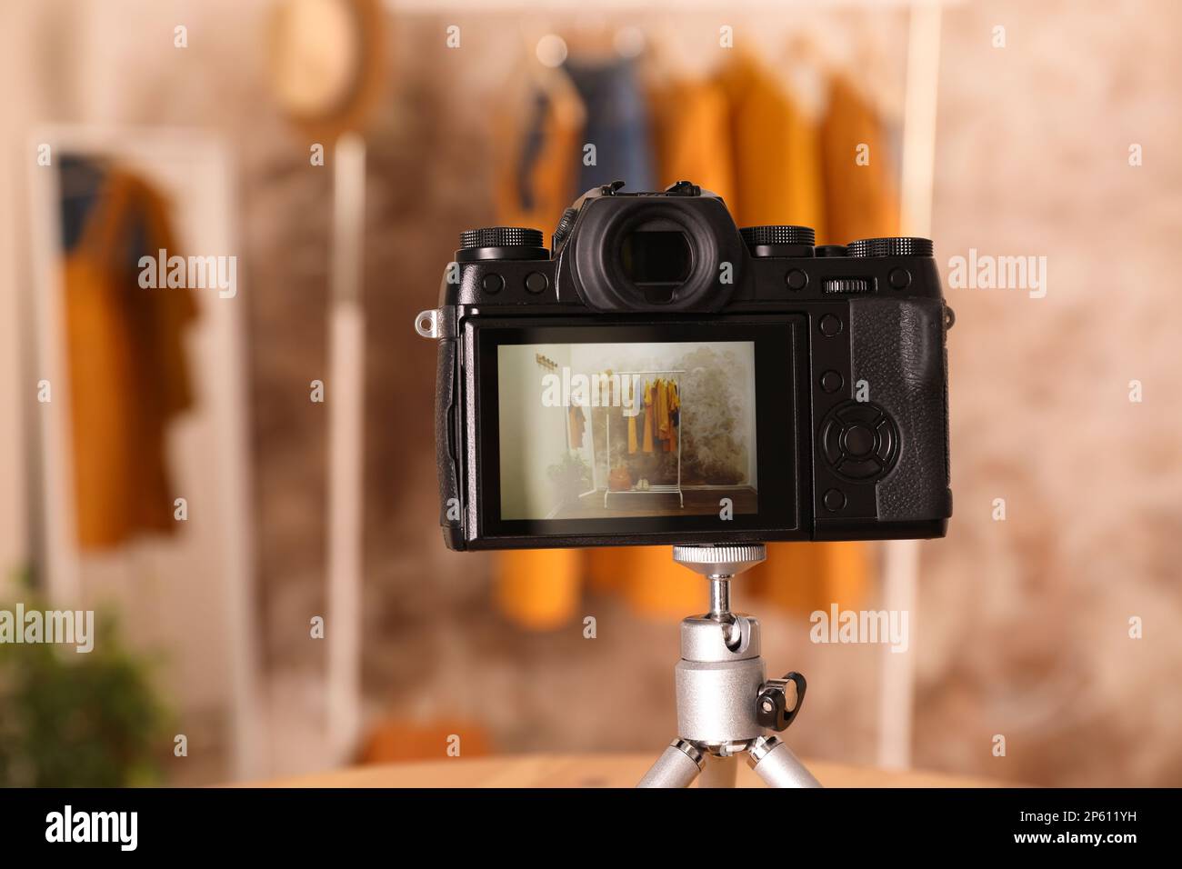 Taking photo of stylish clothes indoors, focus on camera Stock Photo ...