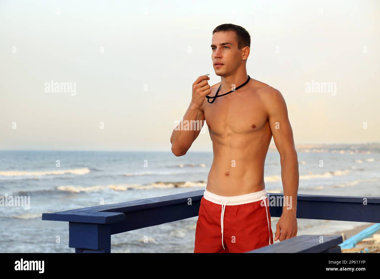 Handsome lifeguard with whistle on watch tower near sea Stock Photo - Alamy