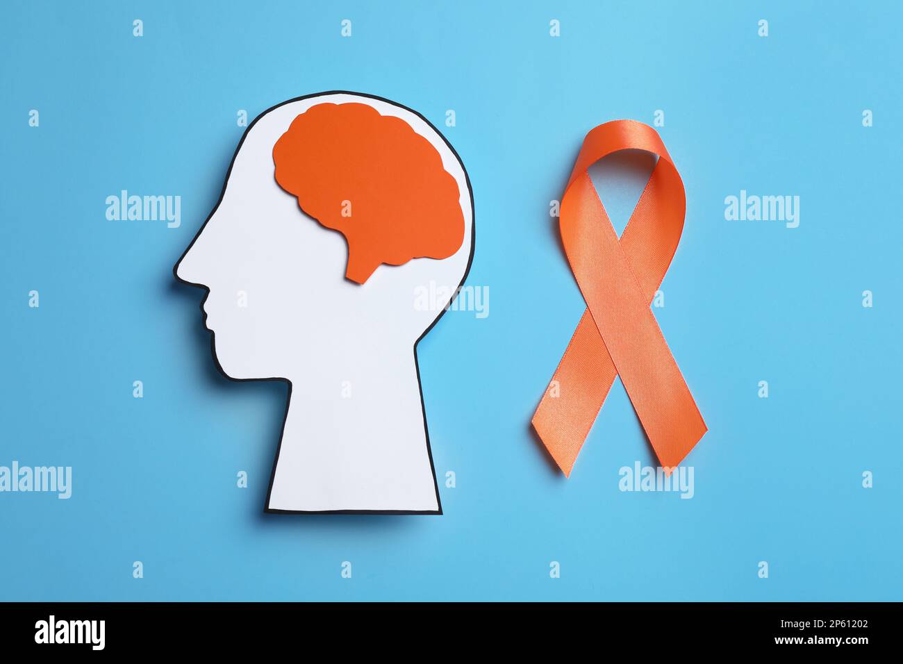 Human head cutout, brain and orange ribbon on light blue background ...