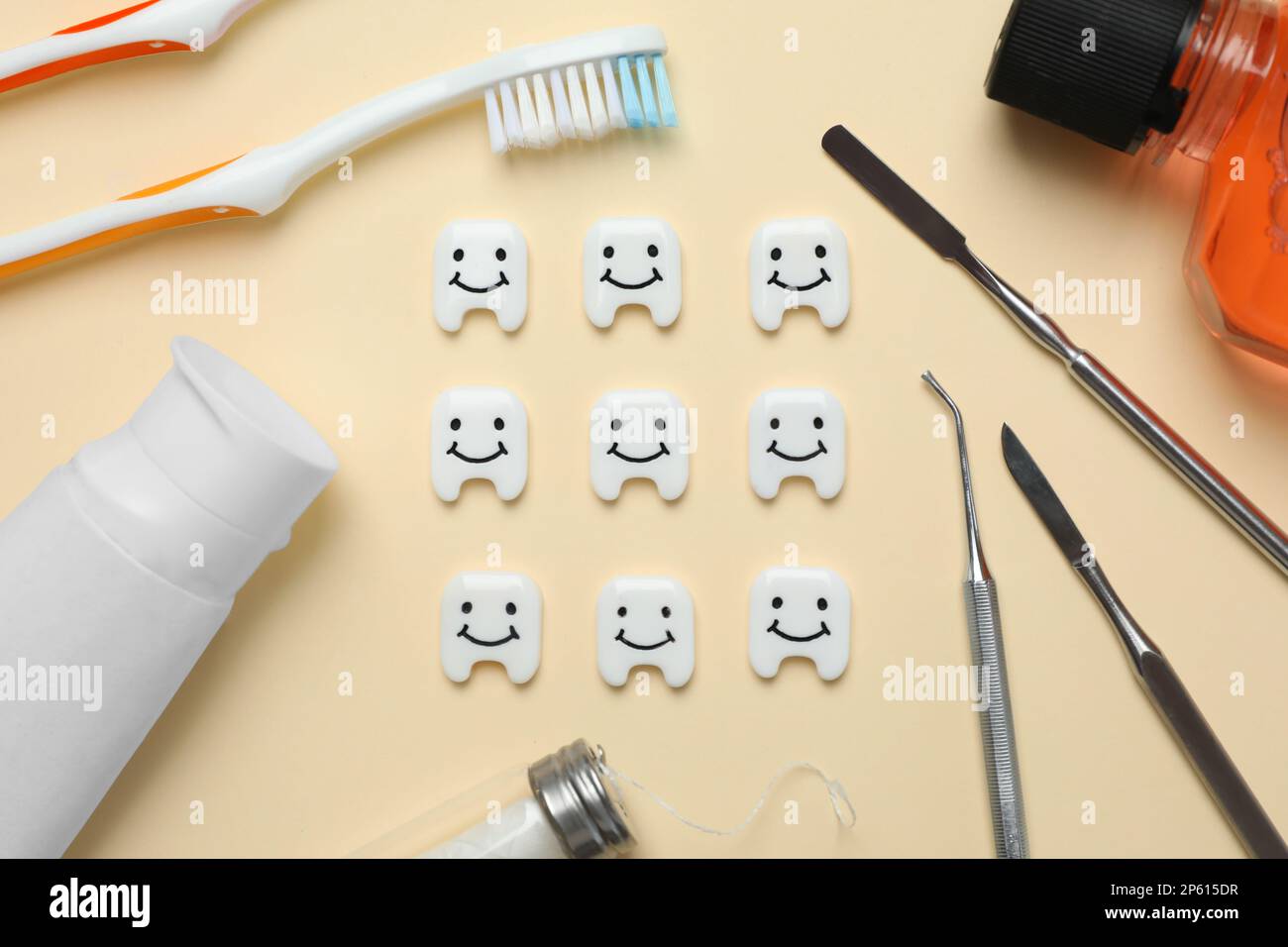 Plastic teeth with cute faces, oral care products and dental tools on ...