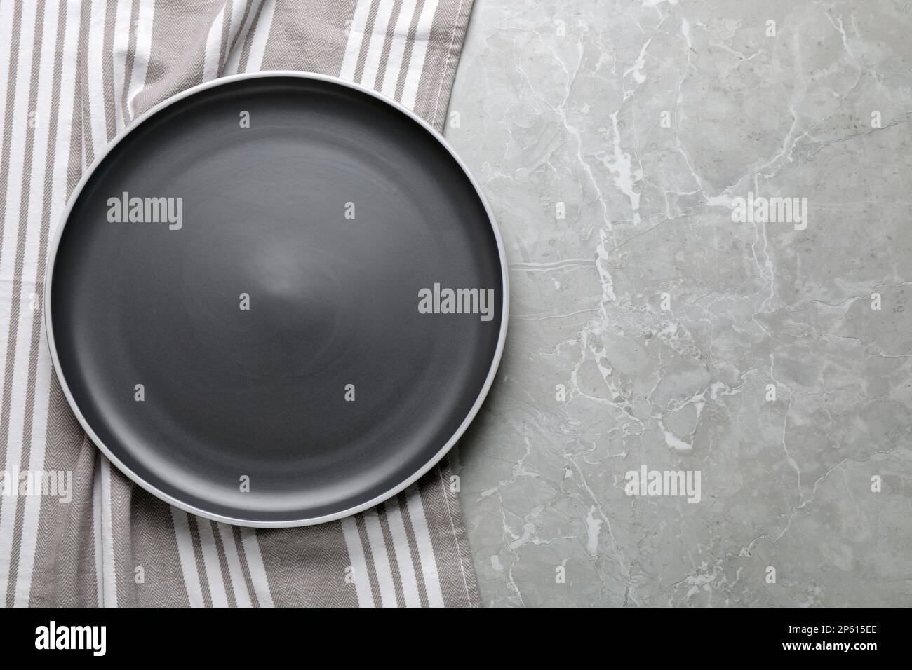 New dark plate and tablecloth on light grey marble table, top view ...
