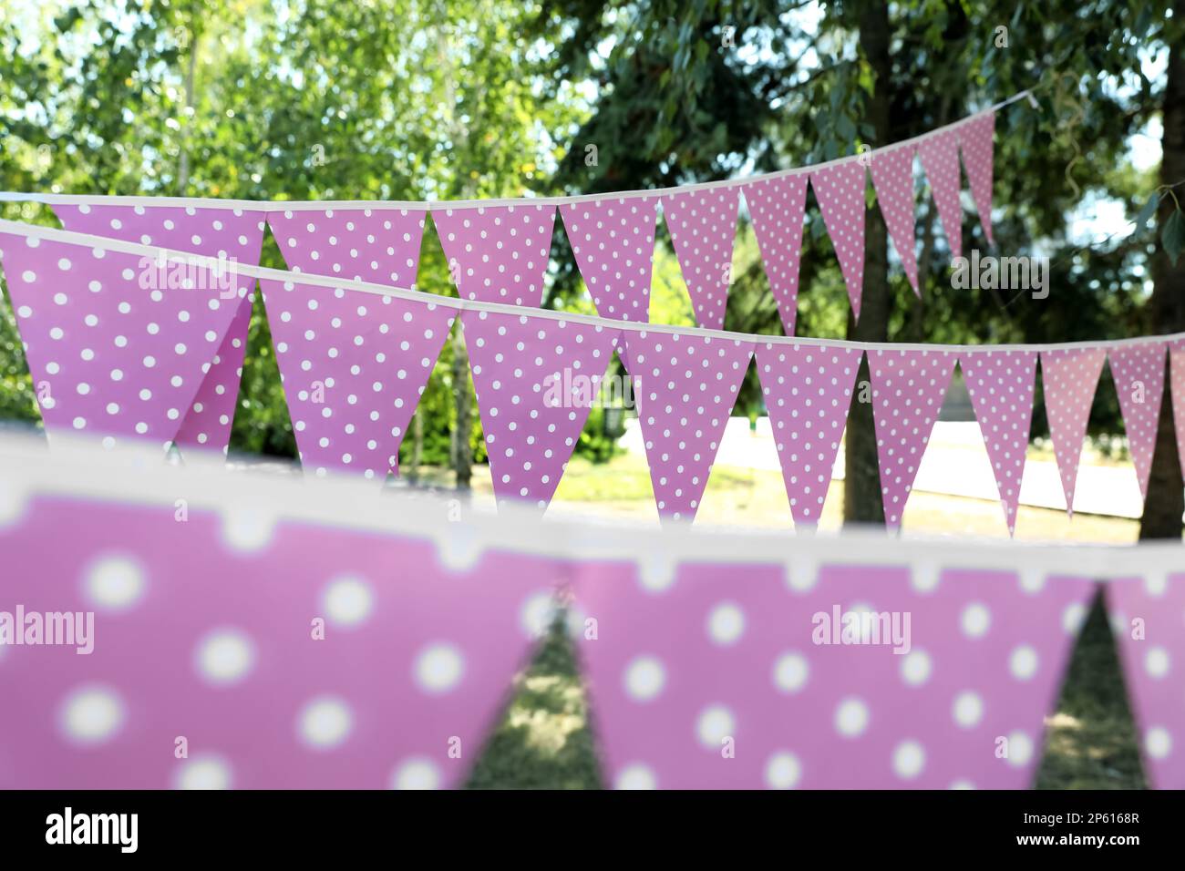 Pink bunting flags in park. Party decor Stock Photo - Alamy