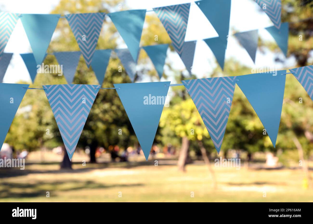 Light blue bunting flags in park. Party decor Stock Photo - Alamy