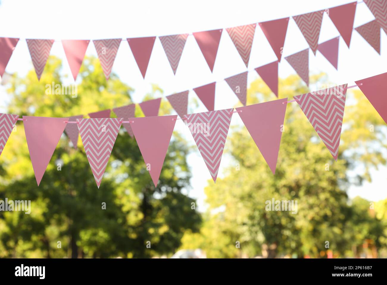 Pink bunting flags in park. Party decor Stock Photo - Alamy