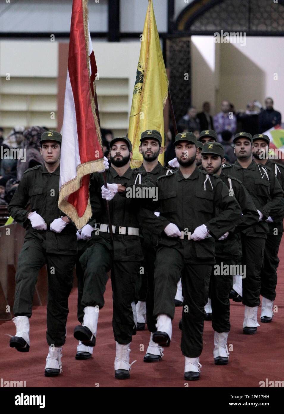 Hezbollah members, hold Hezbollah and Lebanese flag as they march ...