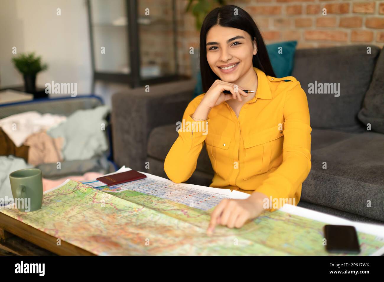 Ready to trip and vacation plan concept. Happy spanish lady sitting ...