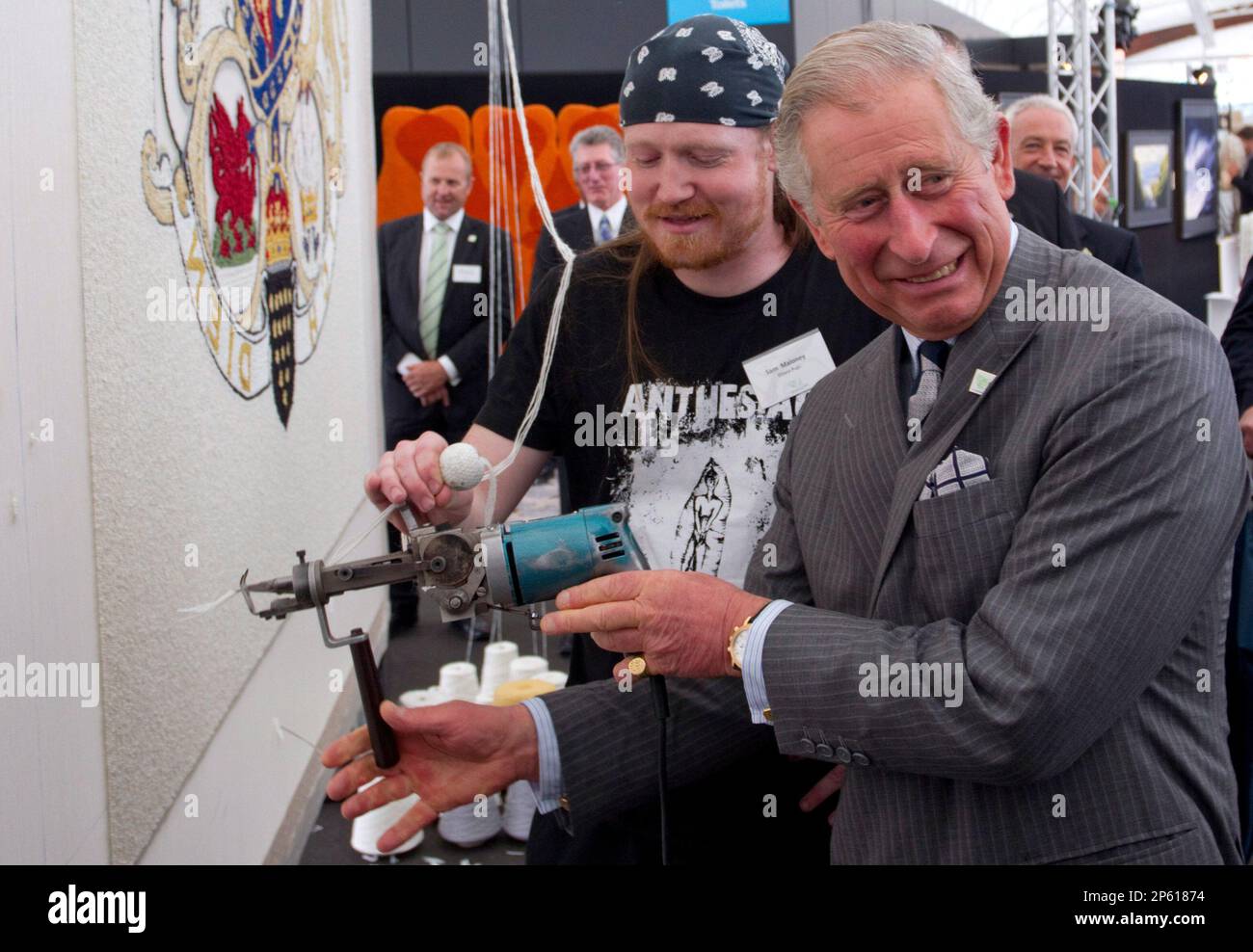 Britain's Prince Charles tries to do some "tufting," watched by tufter ...