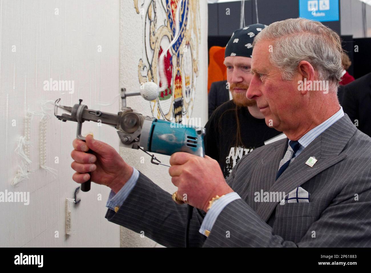Britain's Prince Charles tries to do some "tufting," watched by tufter ...