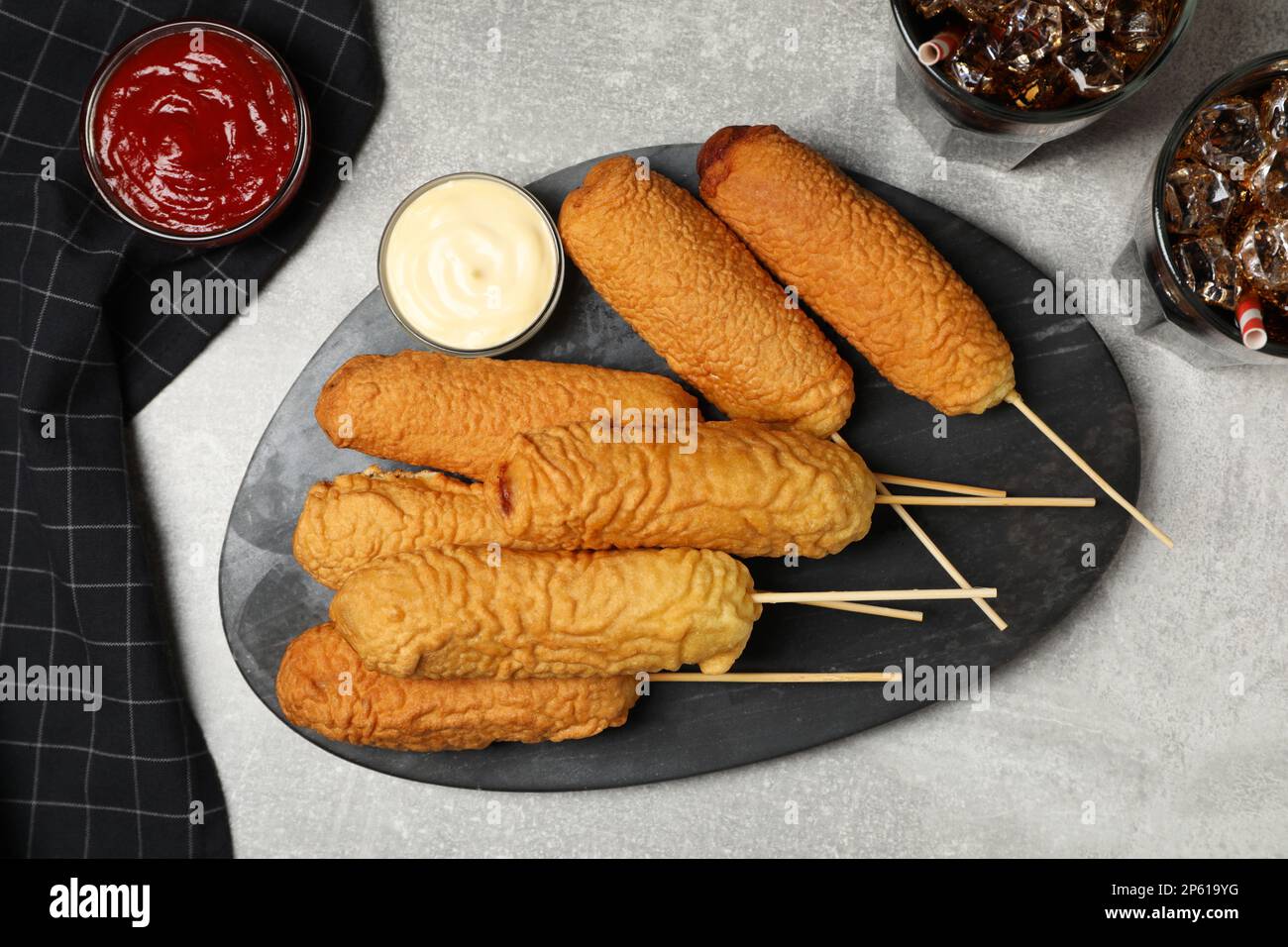 Delicious deep fried corn dogs with board and sauces on light grey ...