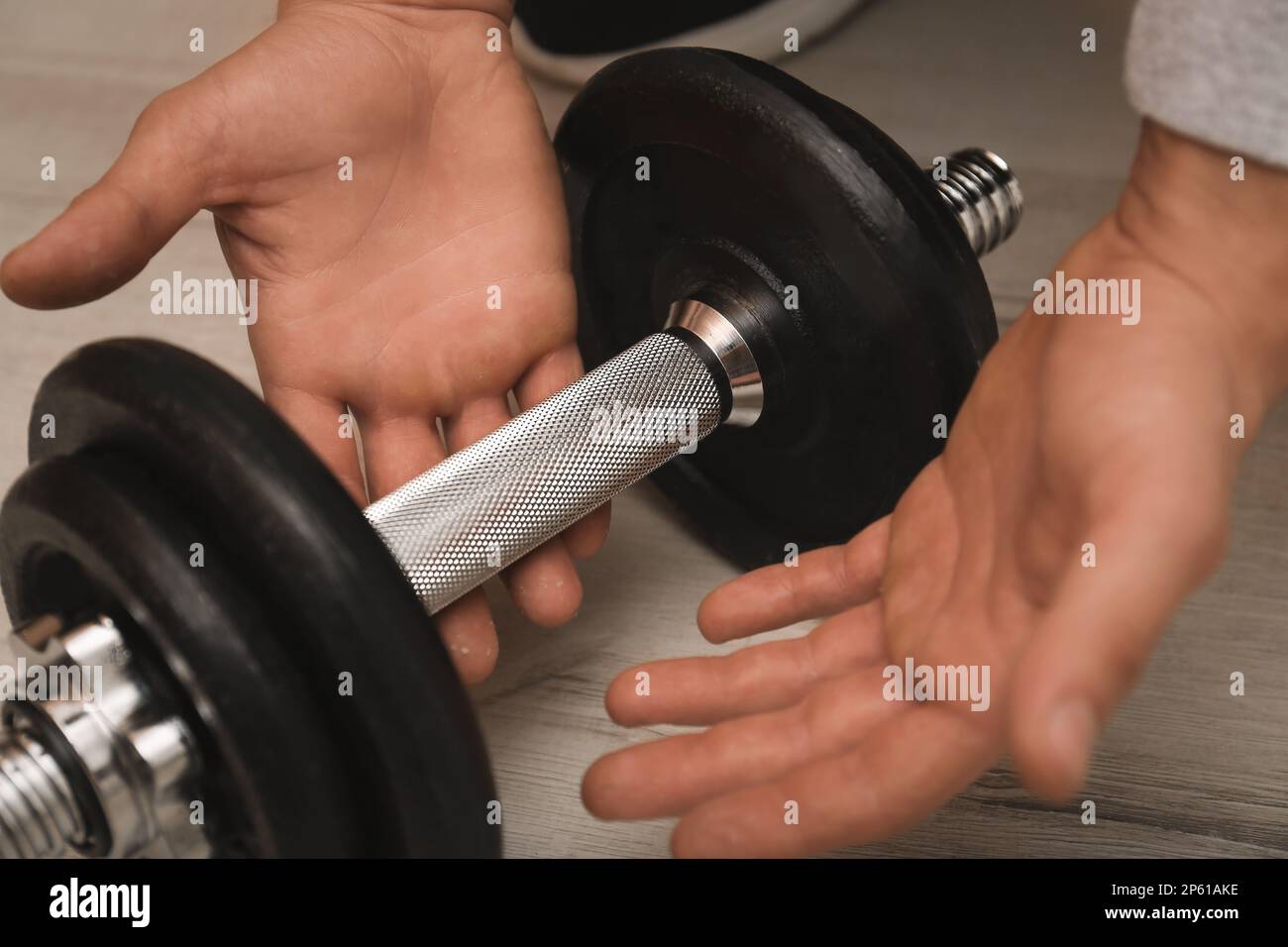 Athlete taking dumbbell indoors, closeup. Suffering from calluses on ...