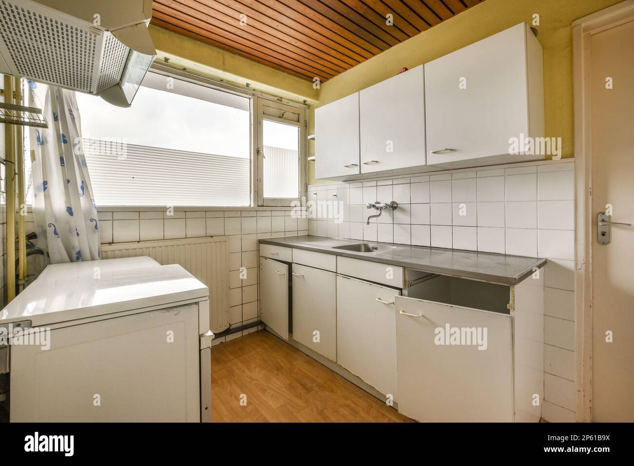 a kitchen with white cupboards and appliances on the counter in front ...