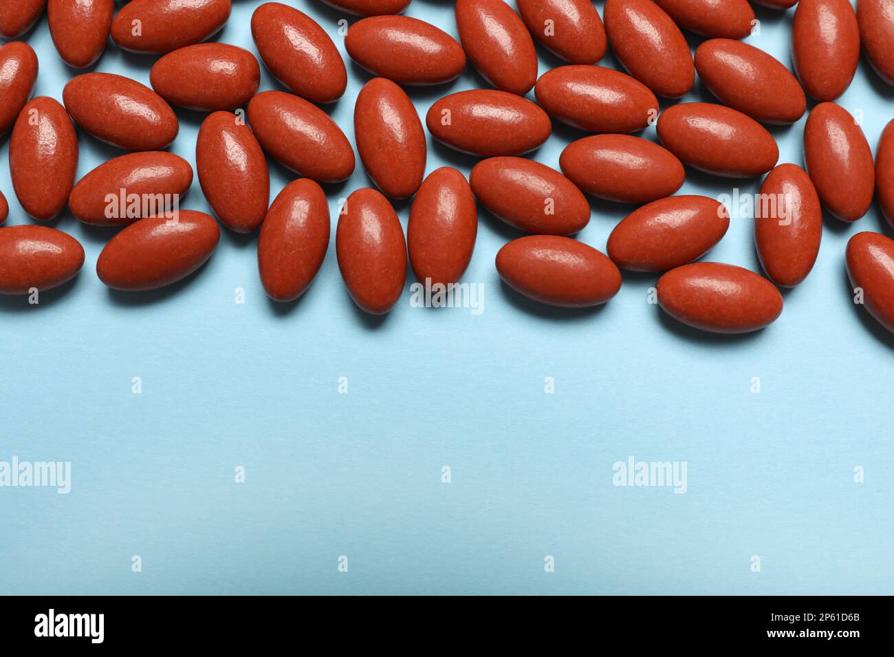 Brown pills and space for text on light blue background, flat lay ...