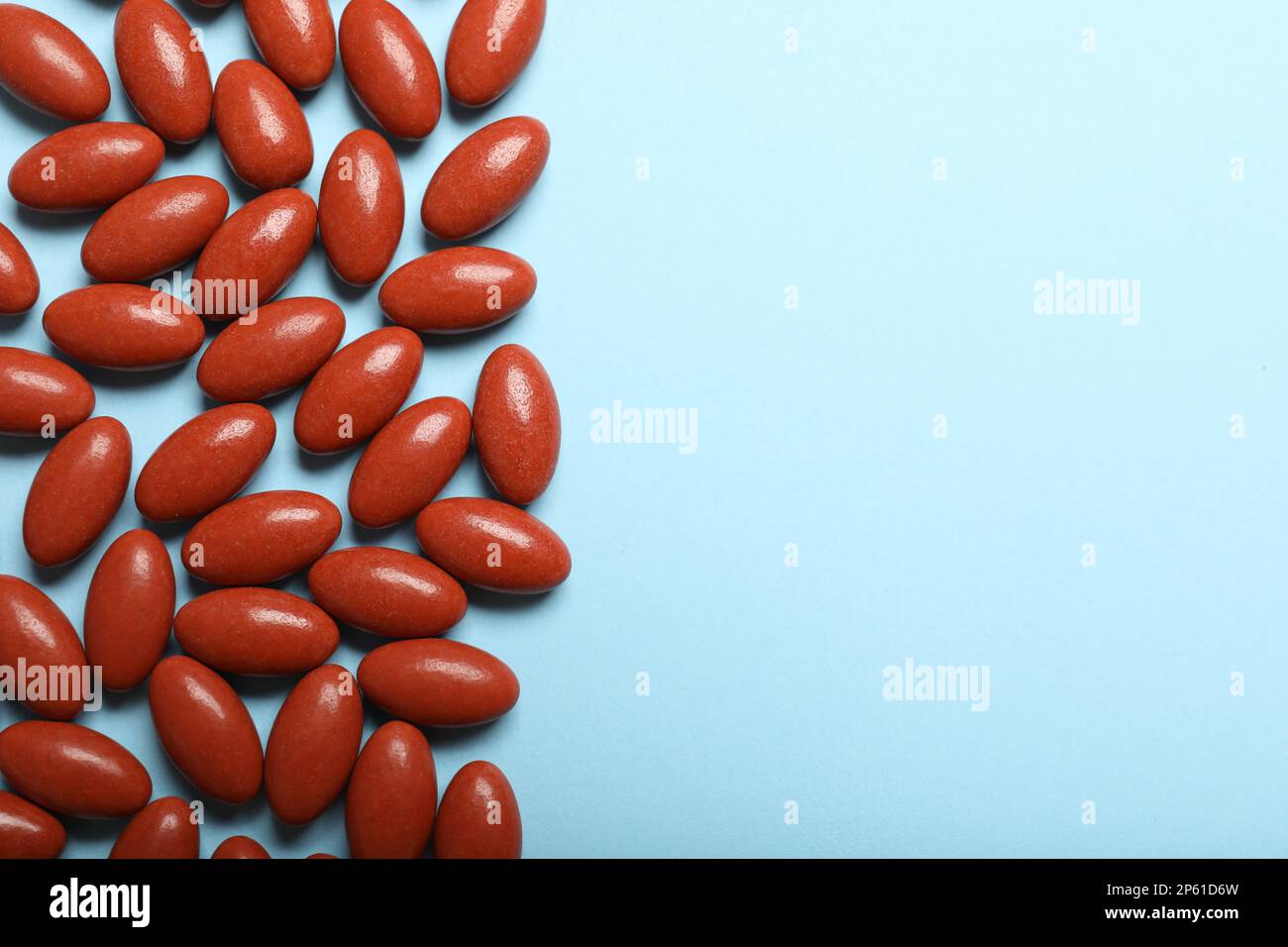 Brown pills and space for text on light blue background, flat lay ...
