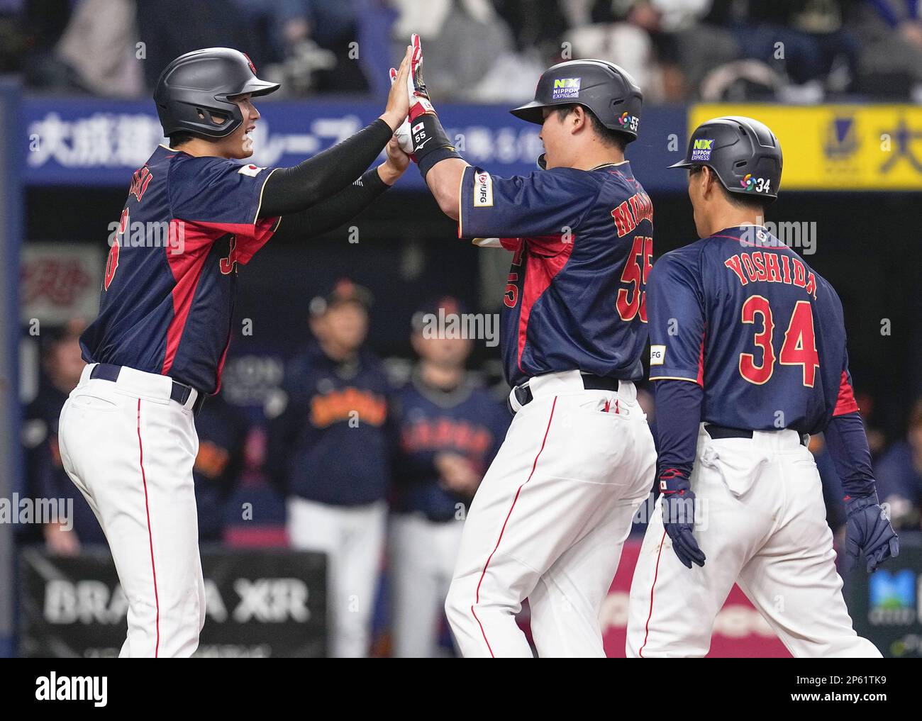 Munetaka Murakami (C) of Japan's national baseball team high-fives with ...