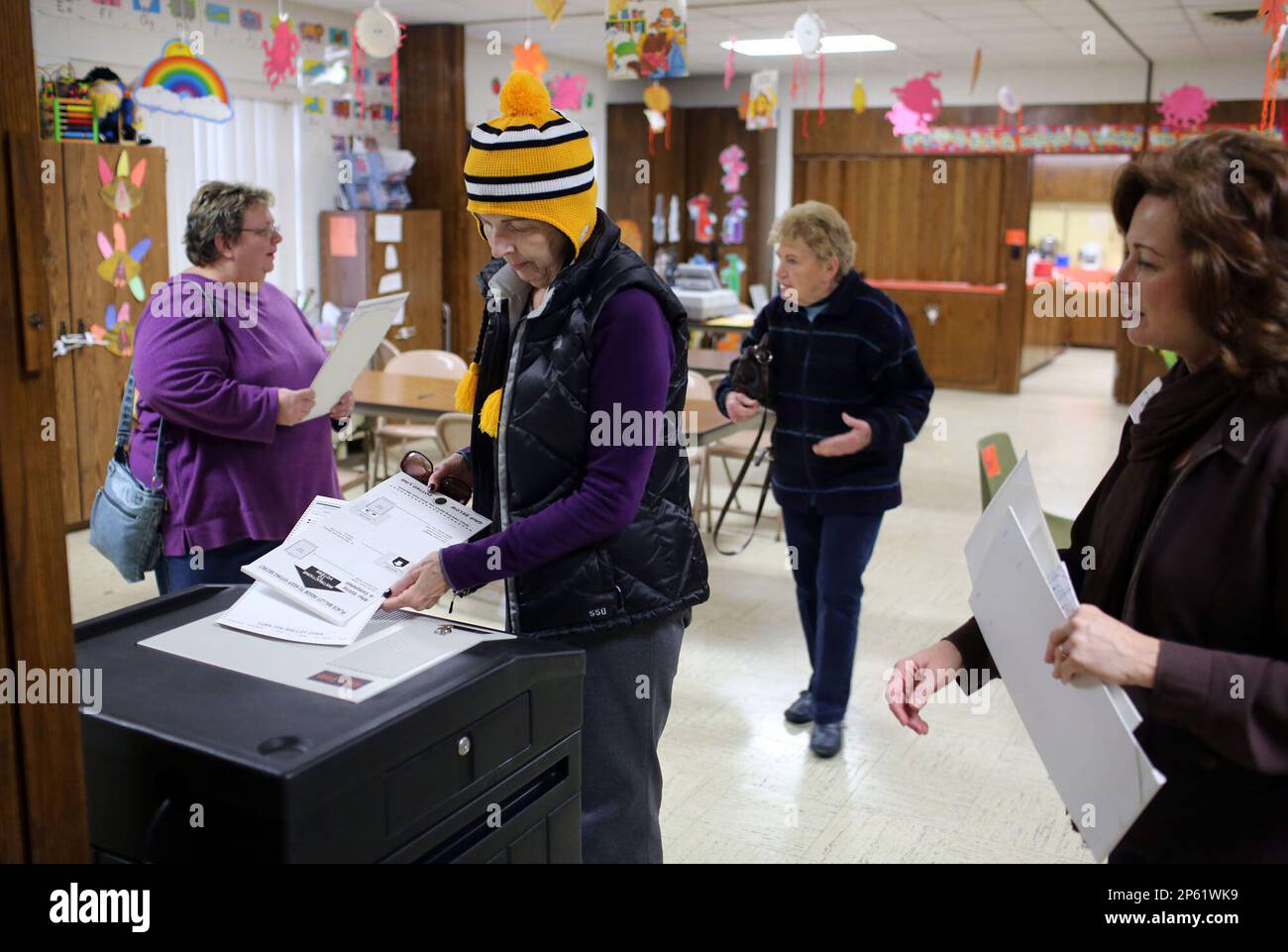 Ruth Ann Bennett, second left, casts her ballot as Lisa Jennison, right ...