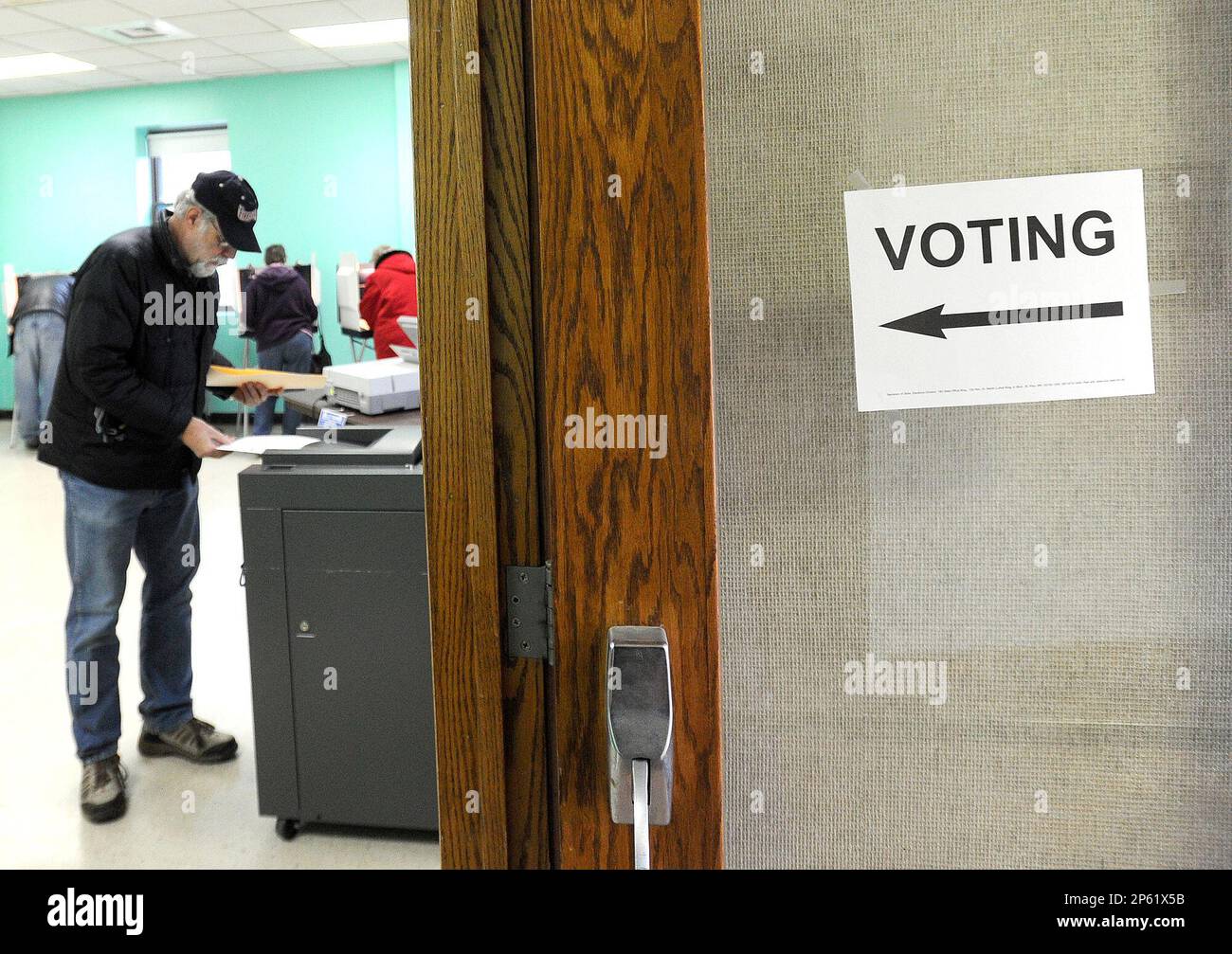 Steve Rozek of Winona, Minn., places his ballot in the voting machine ...