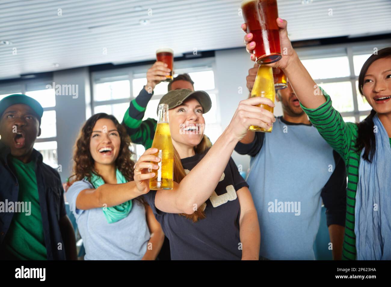 Cheers to the win, boys. A group of friends cheering on their favourite ...