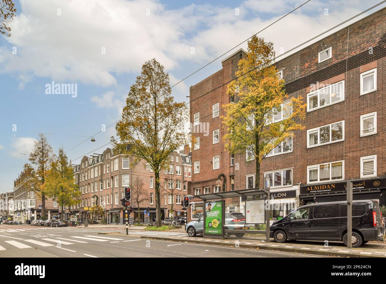 a city street with cars parked on the side of the road and buildings in ...