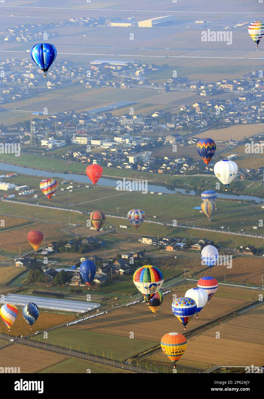 Colorful hot air balloons are floating up in the morning sky at the Saga International Balloon ...