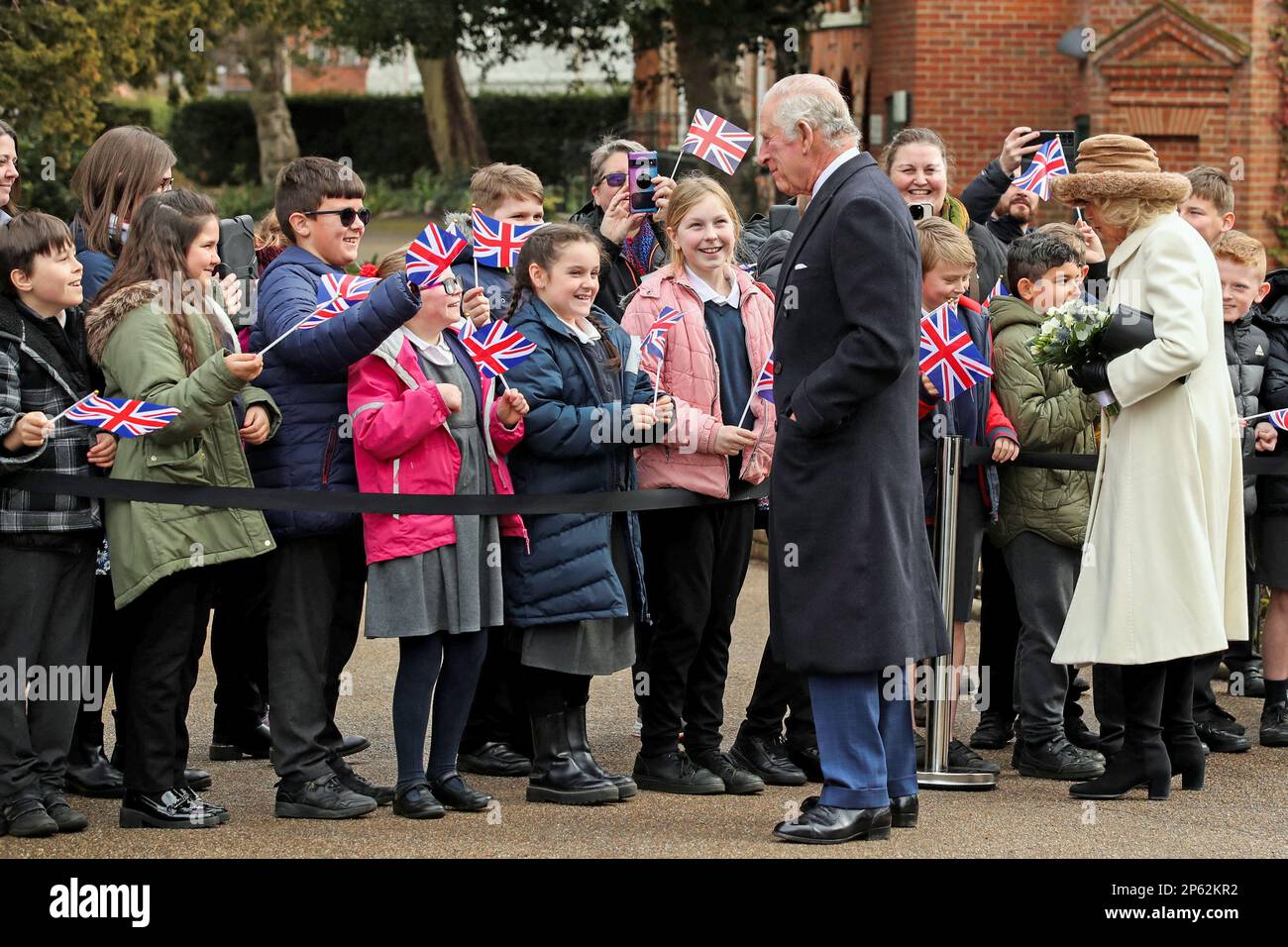 King Charles III and the Queen Consort speak to young children during a ...