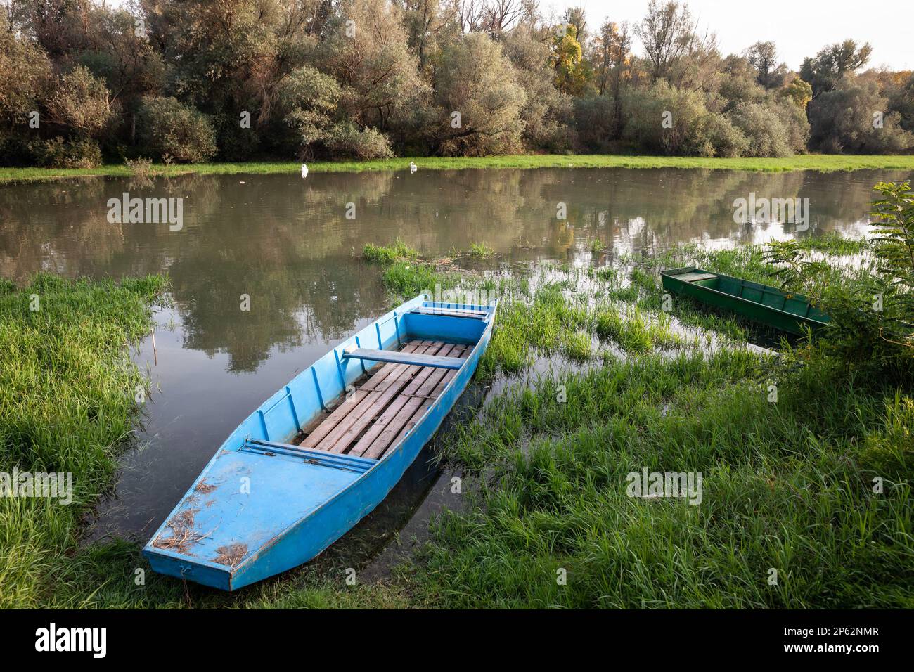 Panorama of an abandoned rowing boat, an blue small boat, resting in ...