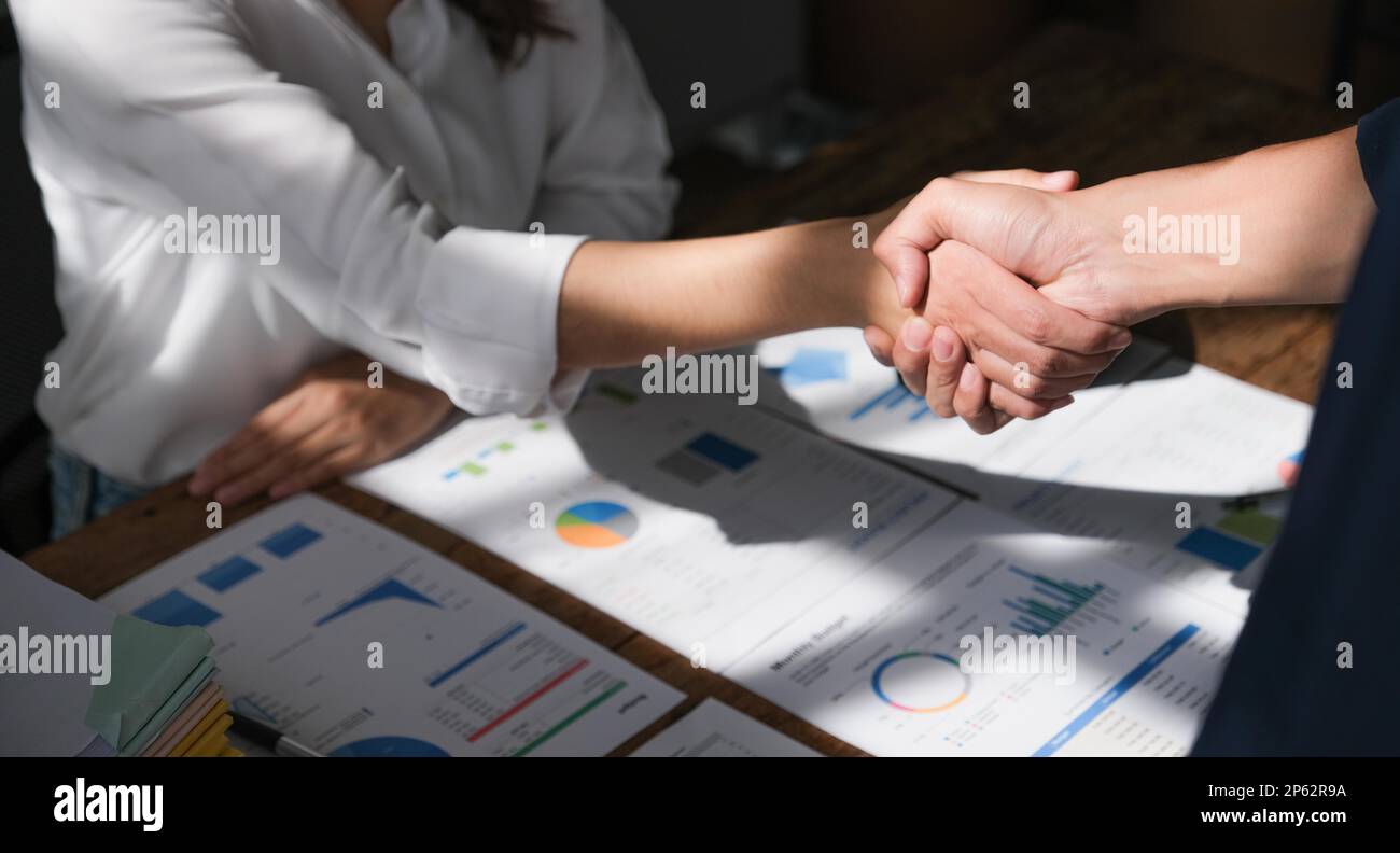 The business people shake hands after the meeting was successful and ...