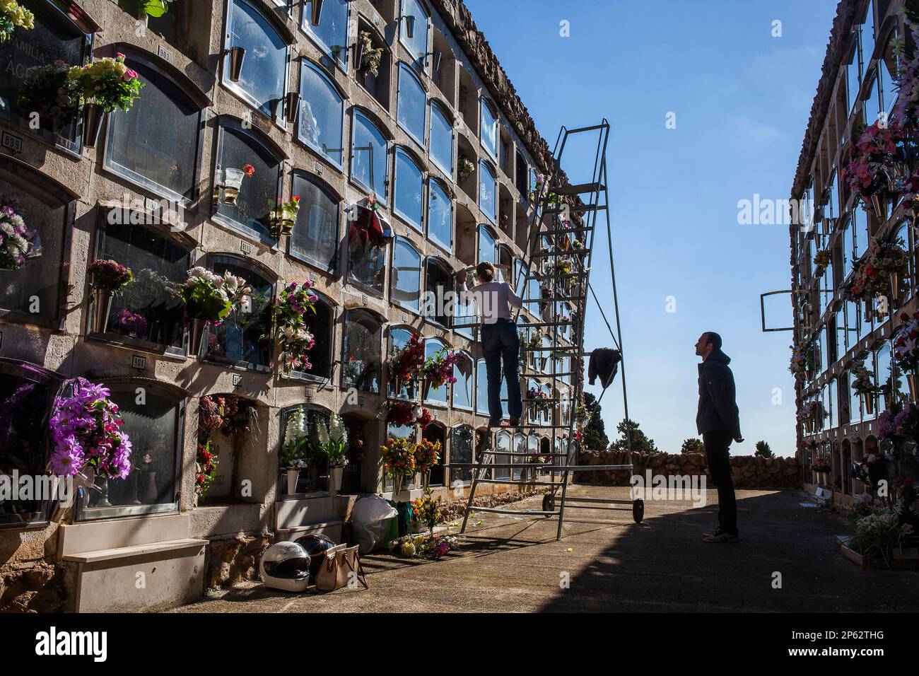 People cleaning a tomb. All Saints' Day. Montjuïc cemetery.Barcelona ...