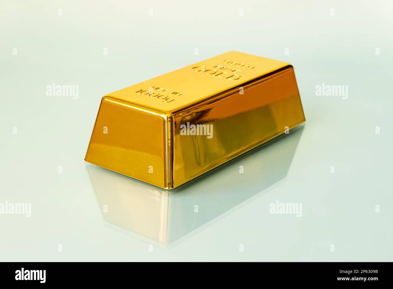 Photo of a 1kg gold bar isolated on a blue background with reflection ...