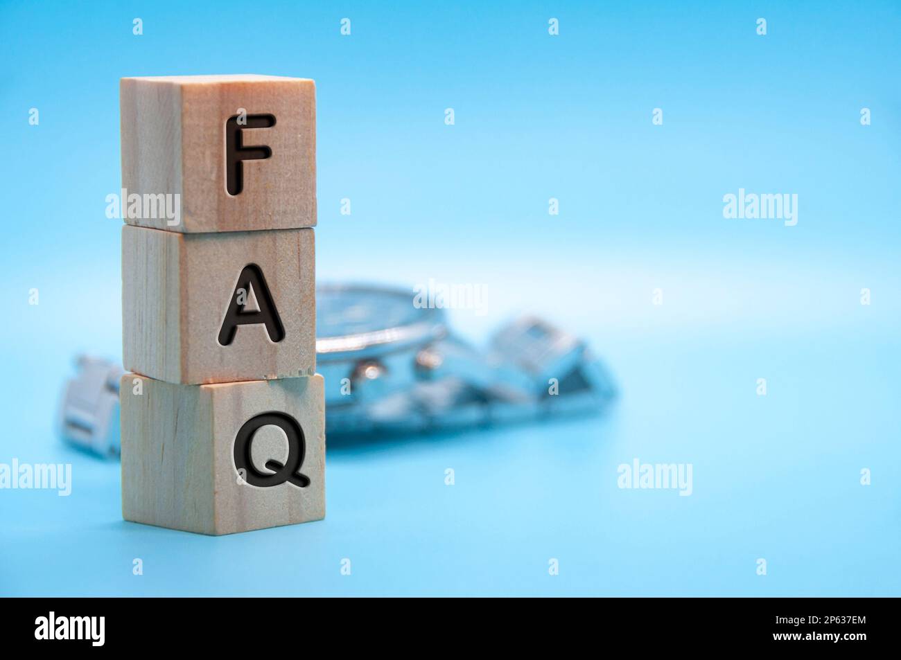 FAQ text engraved on wooden blocks with light blue and watch background ...