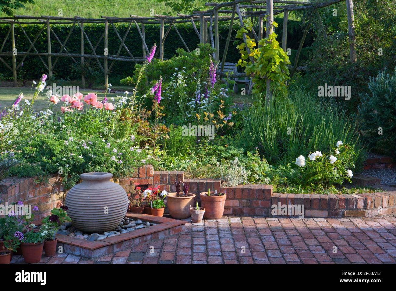 gorgeous brick patio with decorative pots and planting with long wooden ...