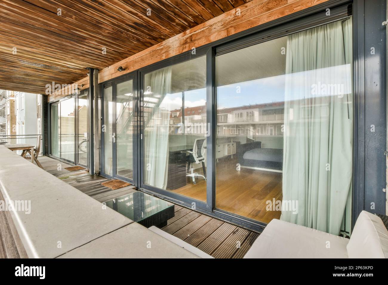 an outside living area with sliding glass doors and wood flooring on ...