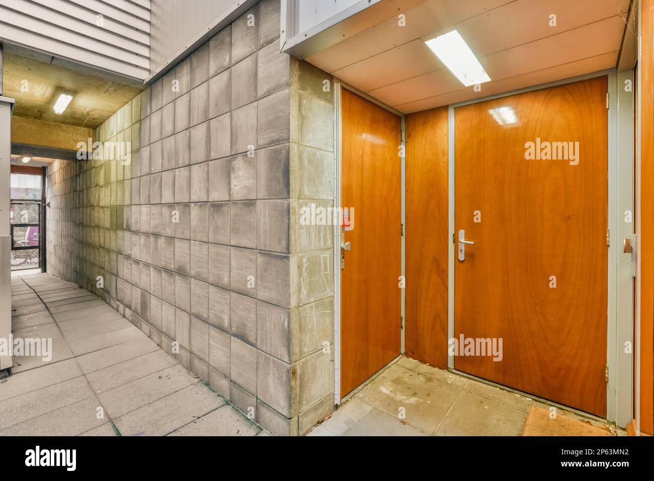 the inside of a building with wood doors and concrete walls in place ...